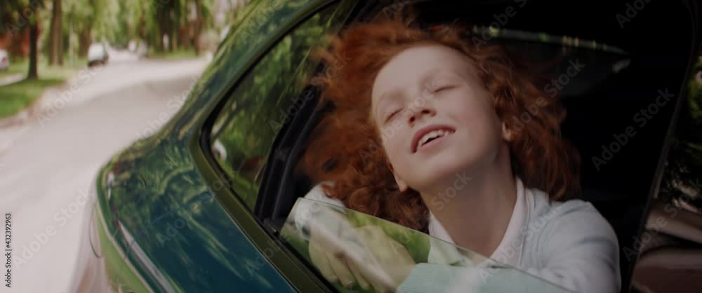 CU Portrait of cute little kid boy sticking head out of car window ...