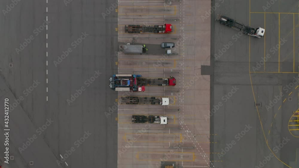 Overhead top down aerial view of a forklift moving cargo from parked ...