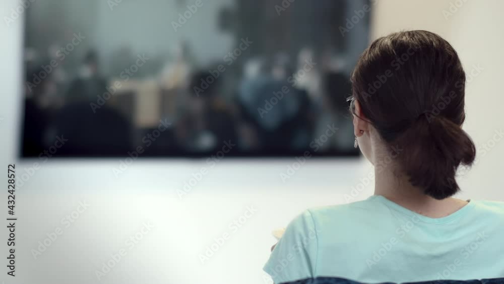 young girl watching tv and eating chips at home, brunette girl watching ...