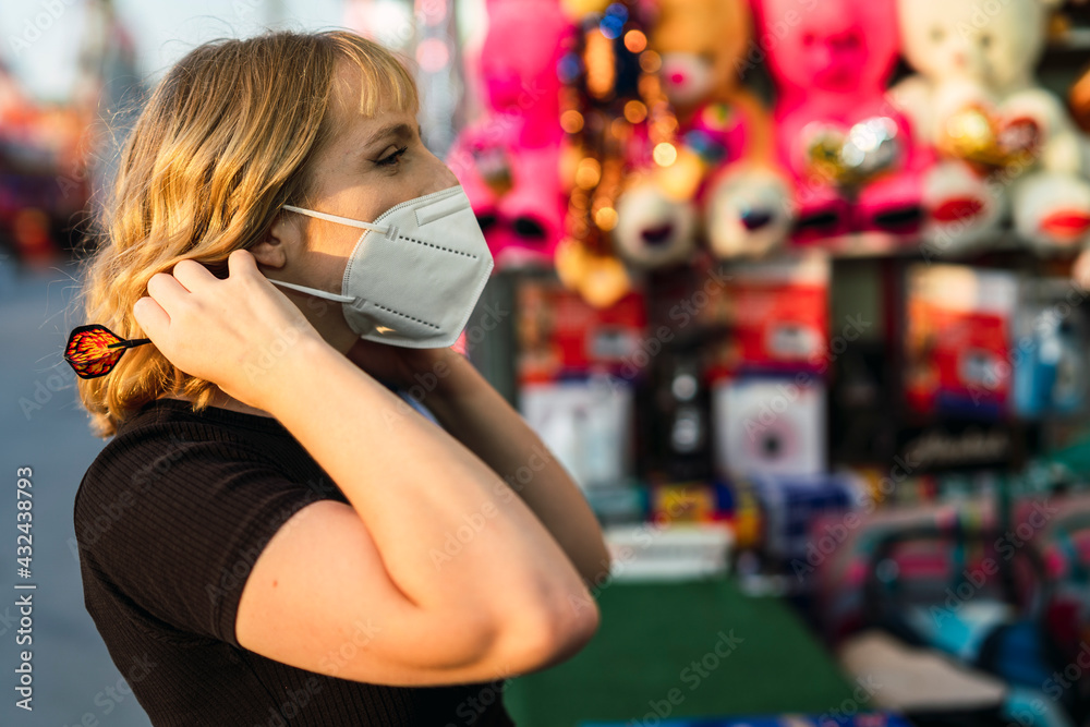 Chica rubia española jugando a explotar globos de colores en puesto de ...