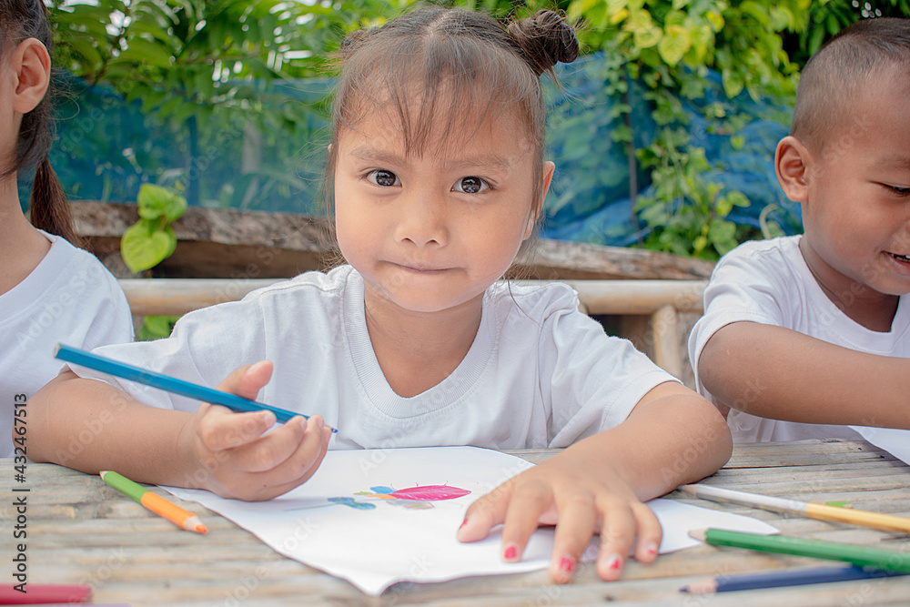 Happy cheerful child drawing using a pencil drawing some ideas while ...