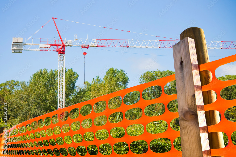 Tower crane in a construction site with metal scaffolding to work on ...