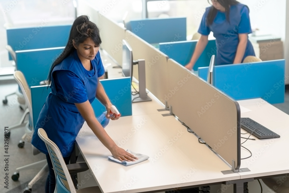 Cleaners clean the desks in the office space.Cleaning and hygiene ...