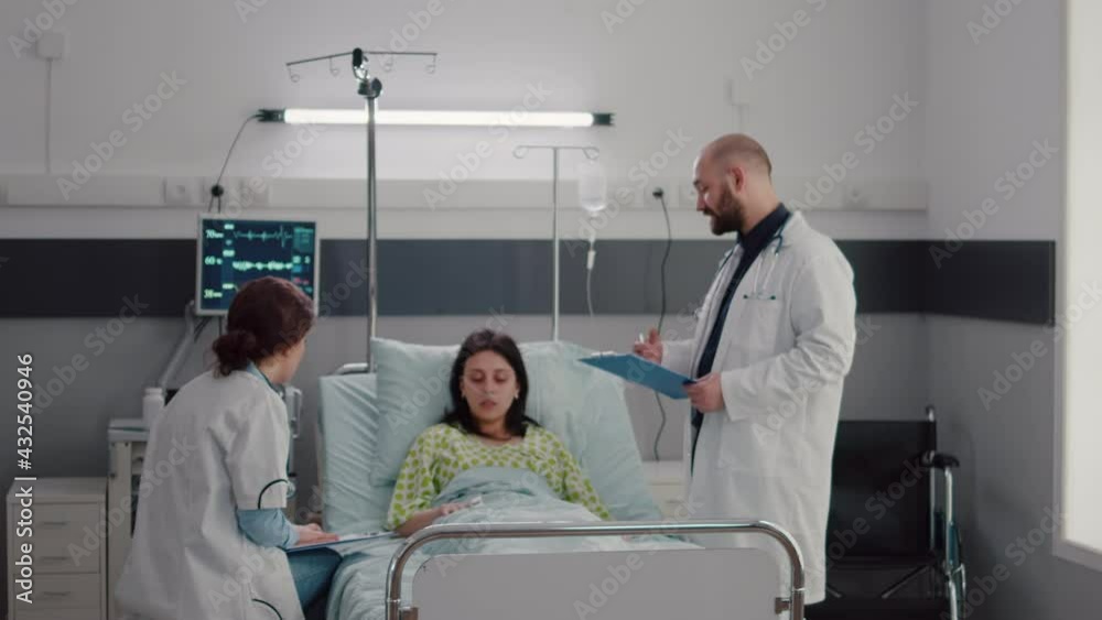 Specialist doctors monitoring sick woman discussing sickness treatment ...