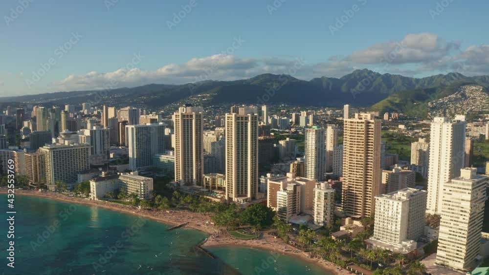 Panning aerial drone slowly flying over a colorful Honolulu Skyline ...
