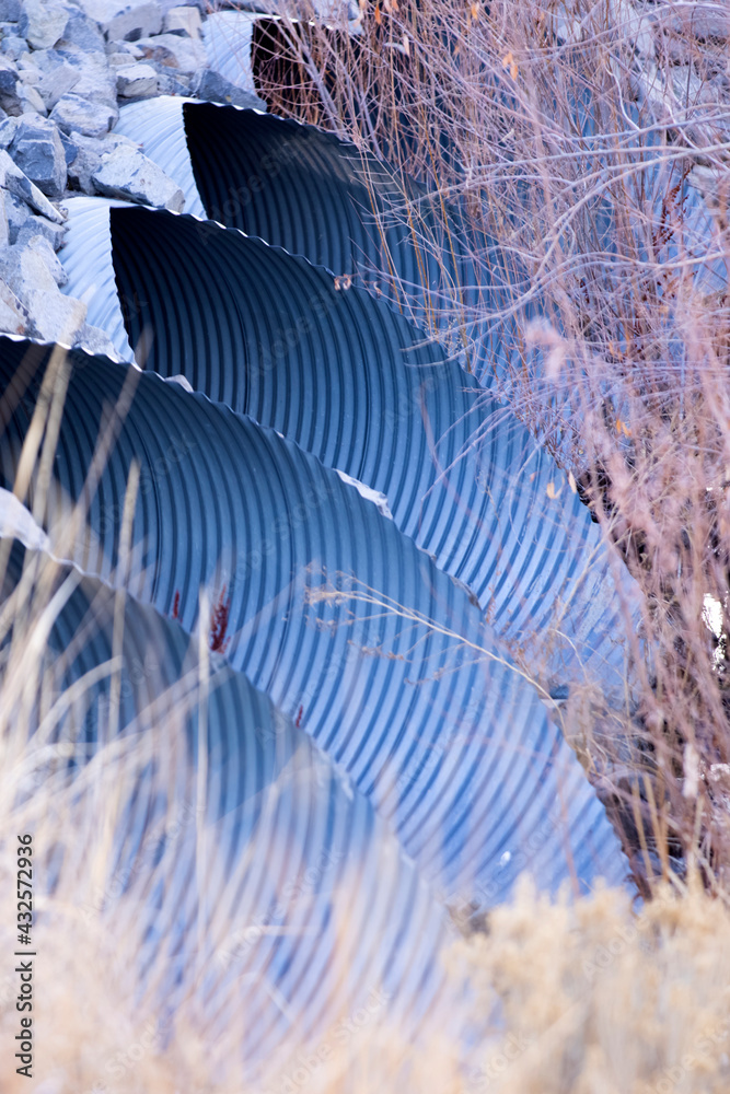 Five parallel pipes lie in a drainage ditch ready for heavy rain and ...