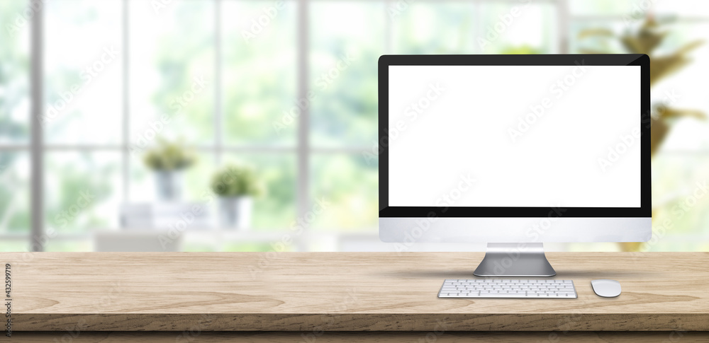 Desktop computer blank screen mockup on wooden table with blur window ...
