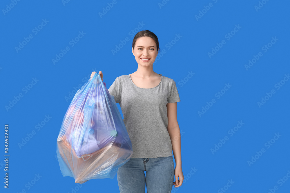Young woman with garbage bag on color background Stock Photo | Adobe Stock