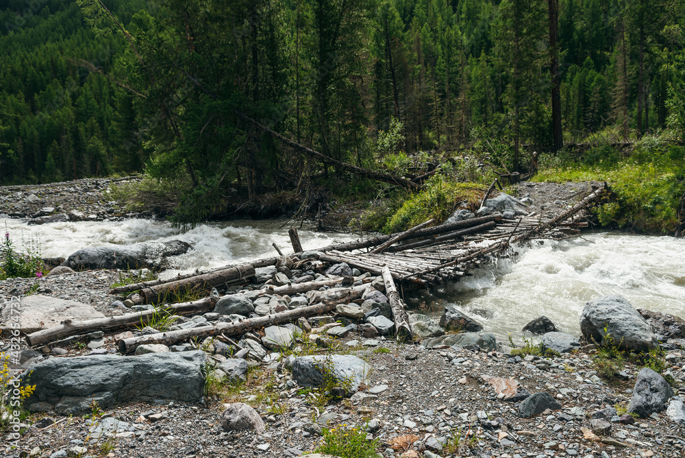 Powerful rapids in fast turbulent river with broken bridge in water ...