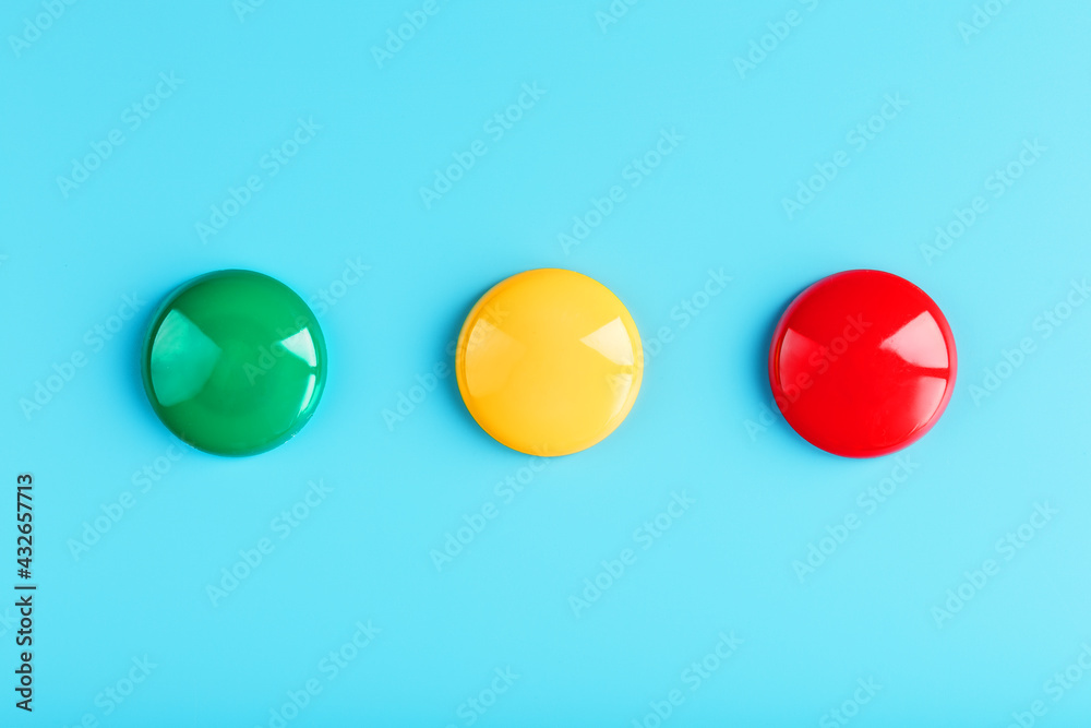 Green yellow and red round magnet in a row on a blue background in the ...