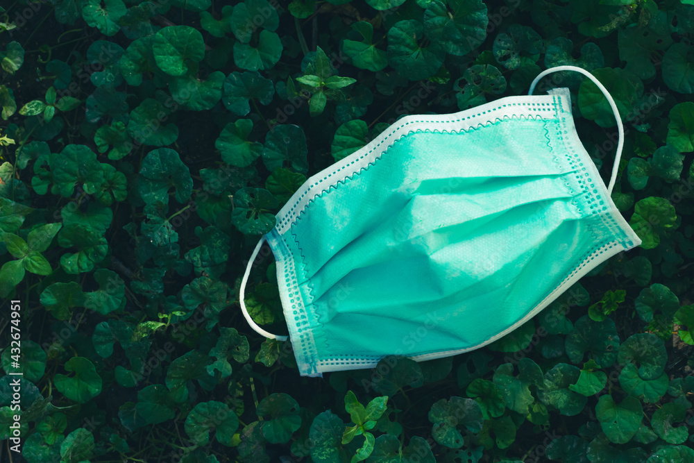Disposable face mask on cement road, top view. Pollution from overuse ...