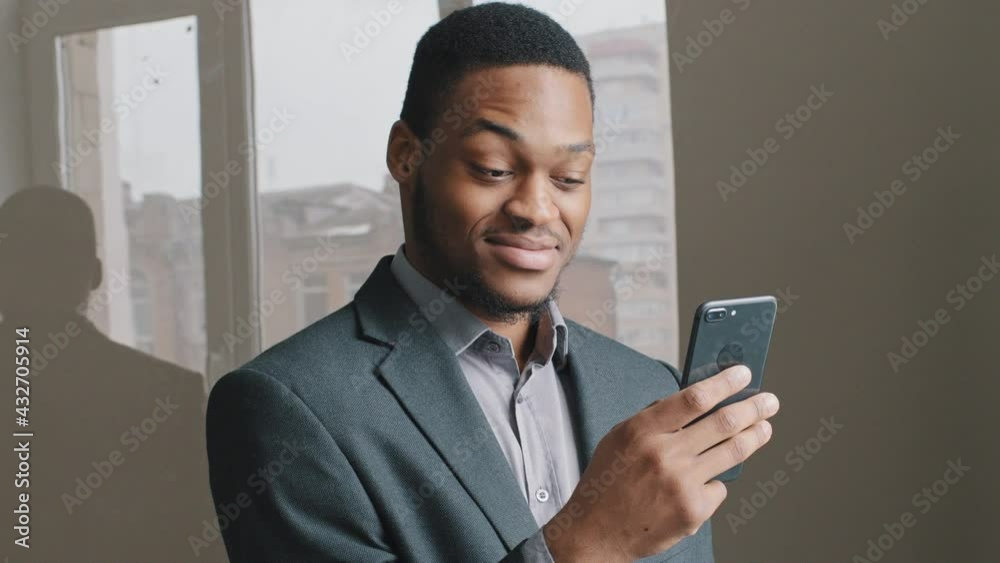 Excited black man working in digital app hold smartphone read good ...