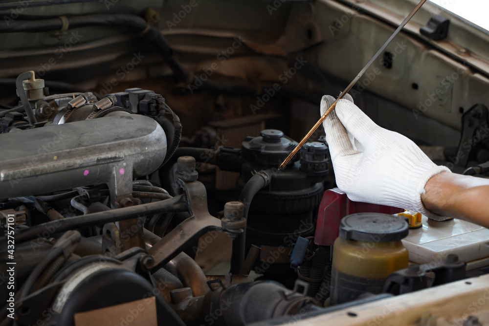 Auto mechanic checking the oil level in car engine,inspects engine water level dipstick,Check ...