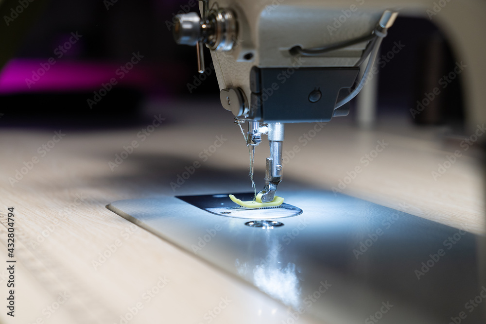 Closeup of modern sewing machine needle and fabric. Tailor or ...
