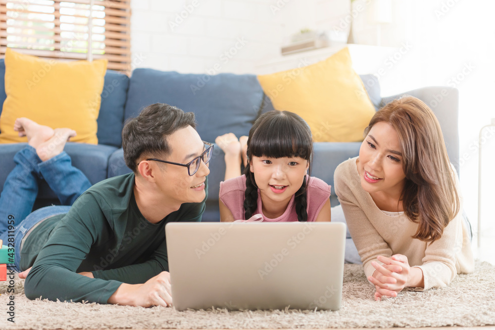 Happy Asian family using computer laptop together on sofa at home ...