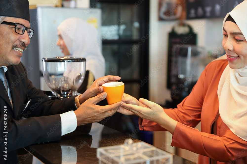 muslim customer businessman wearing black suit receive a cup of coffee ...