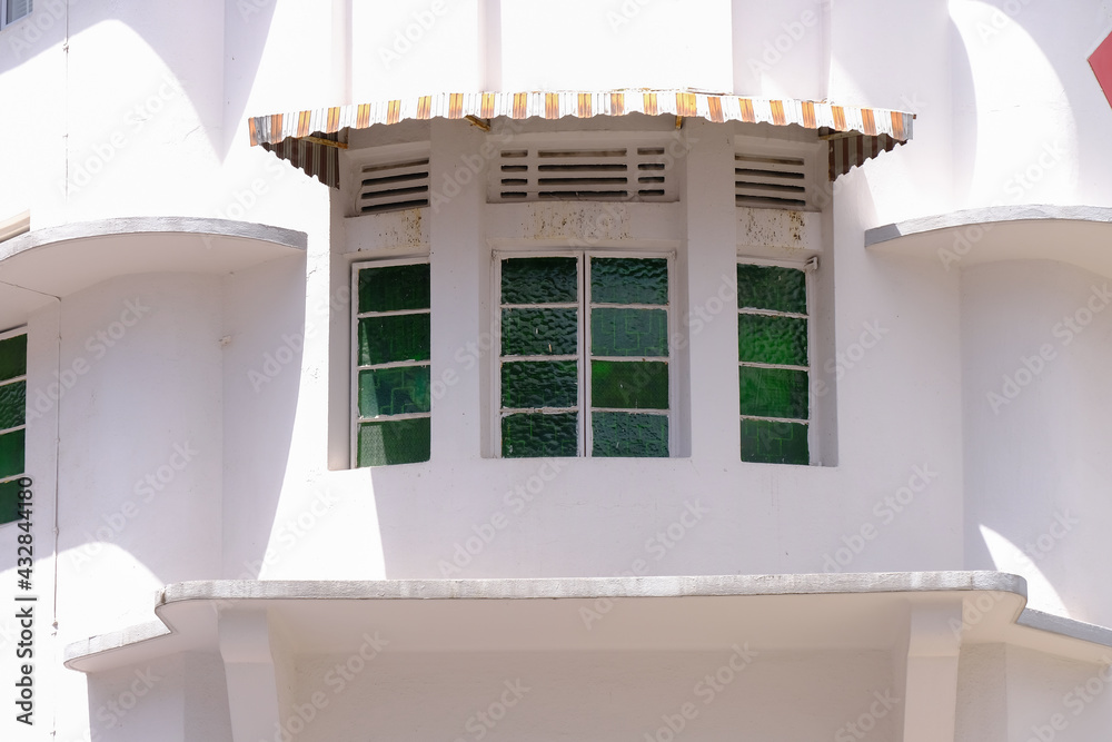 Close up of common windows with awning and vintage green panes ...