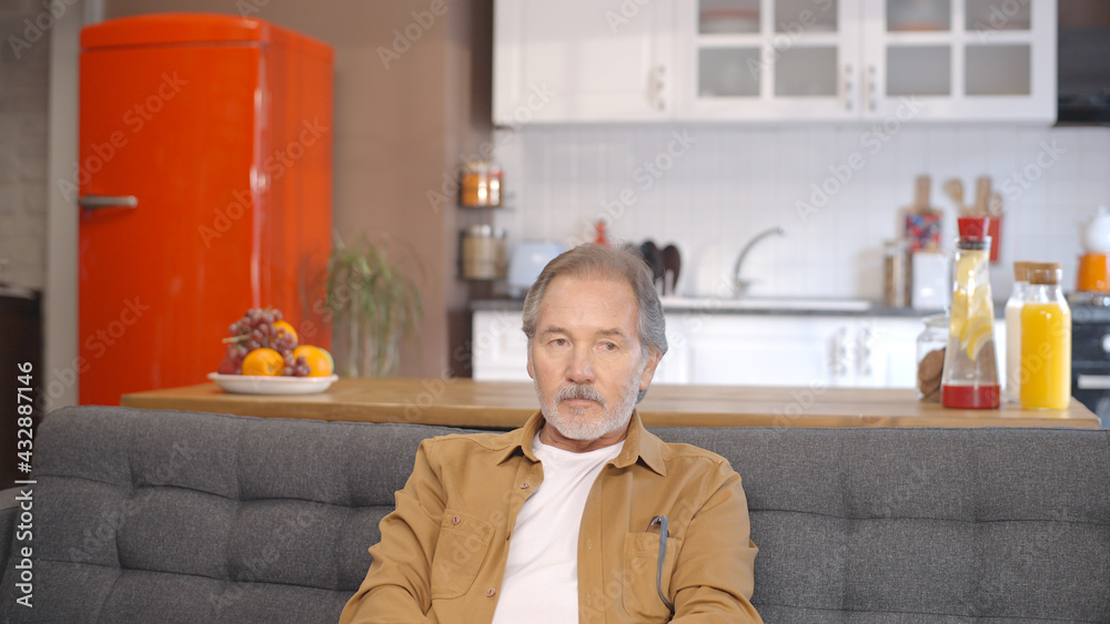 The thoughtful bearded old man turns to the screen and looks ...