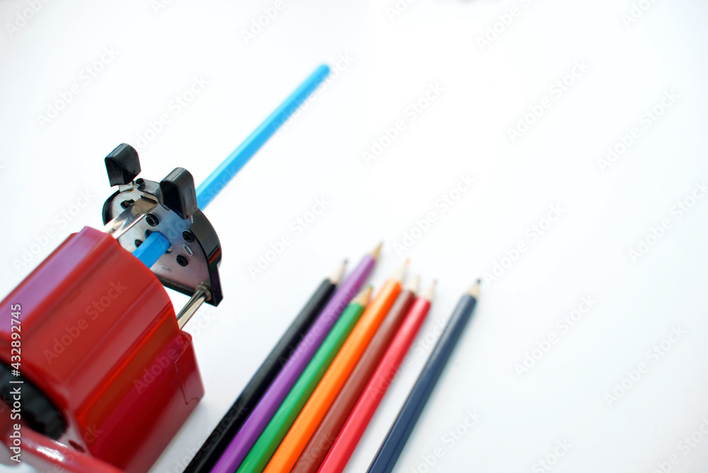 Mechanical pencil sharpener with colored pencils on a white background ...