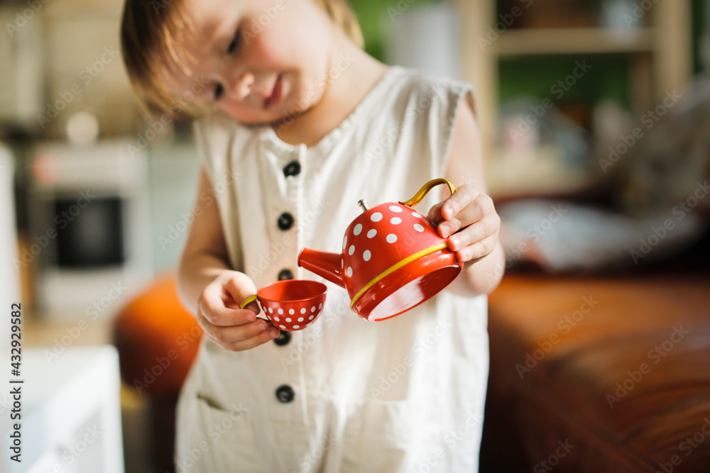 Cute caucasian child toddler playing with toy utensils, child pouring ...