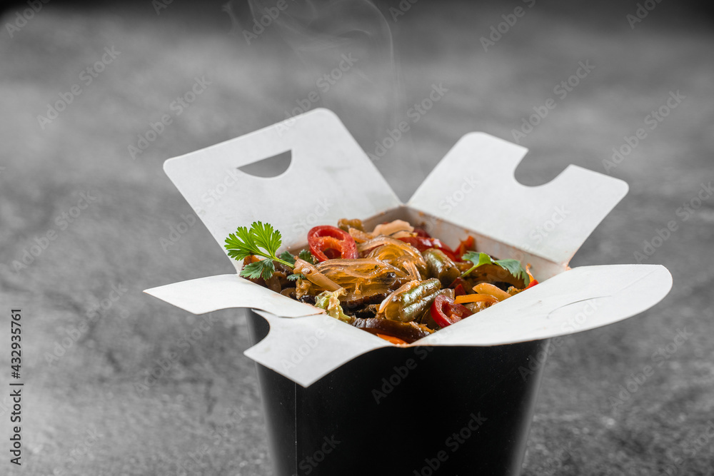 Wok in box rice noodles in black food container. Fast food delivery ...
