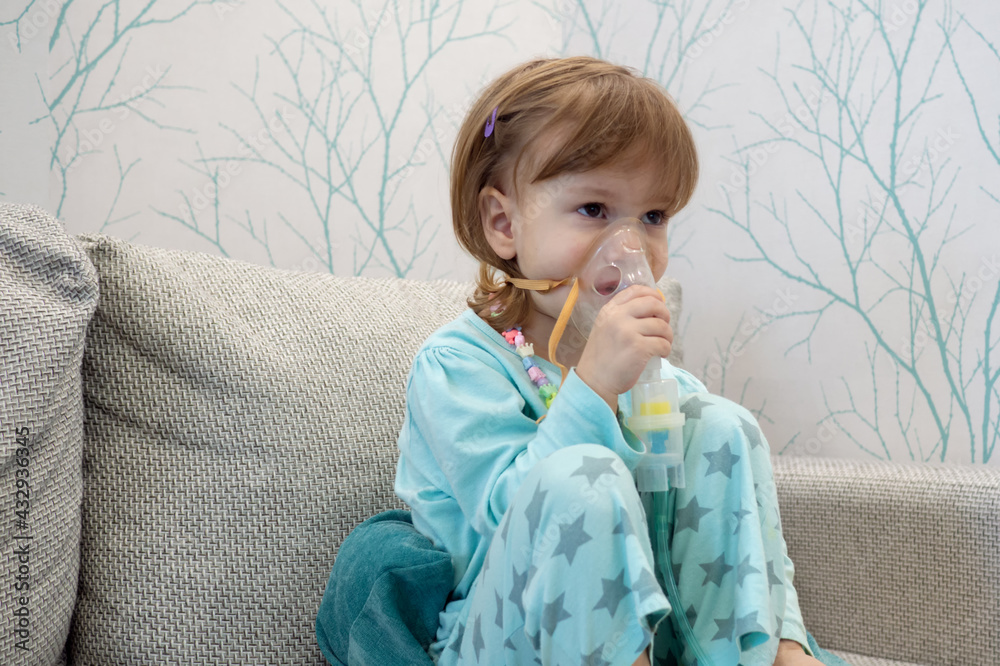 Kid girl makes inhalation with a nebulizer. sick child holding ...