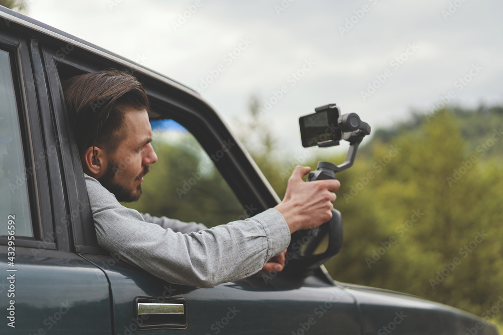 Side view of influencer man films a travel video using smartphone with ...