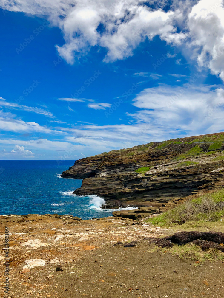 Rocky cliffs and Pacific Ocean wake surf along shoreline of coast of ...