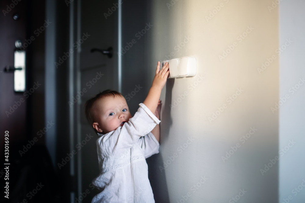 Cute baby toddler presses the switch, the child includes light. Concept ...