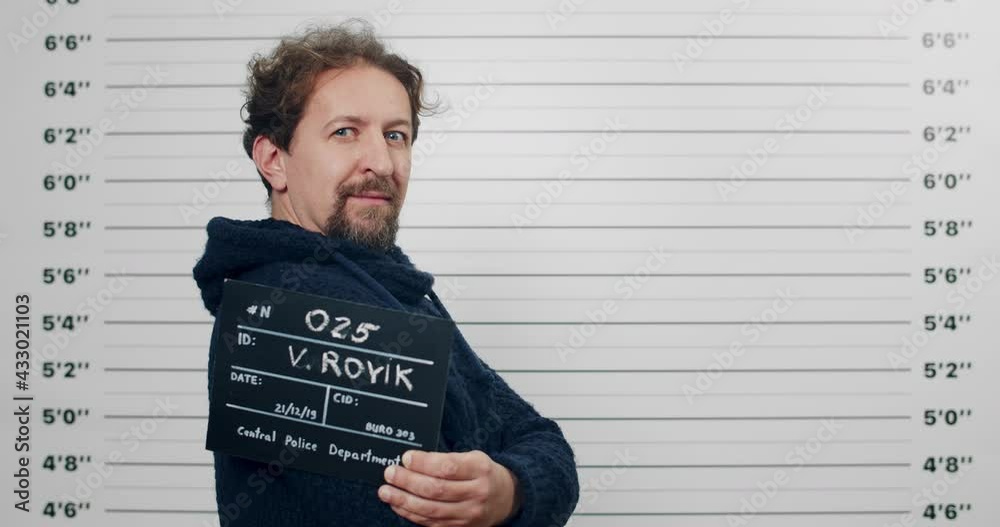 Side profile mugshot of male arrested in 40s turning head and looking ...