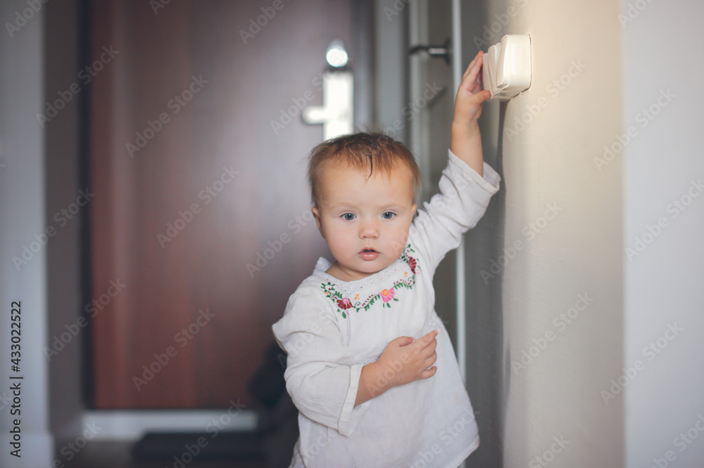 Cute baby toddler presses the switch, the child includes light. Concept ...