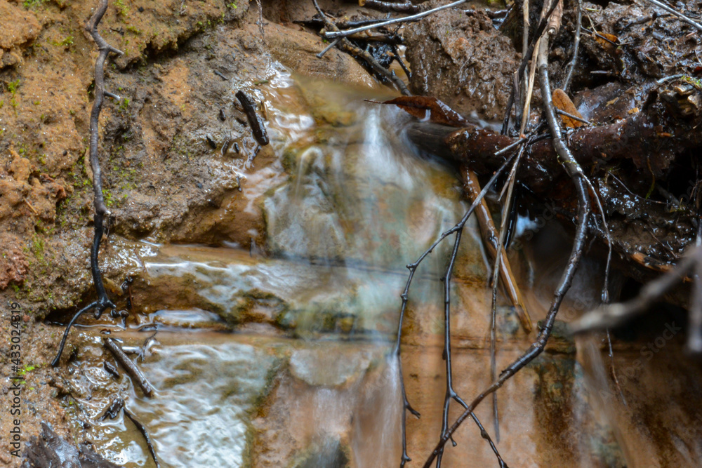 underground spring water flows on the sandstone rock wall. Long ...