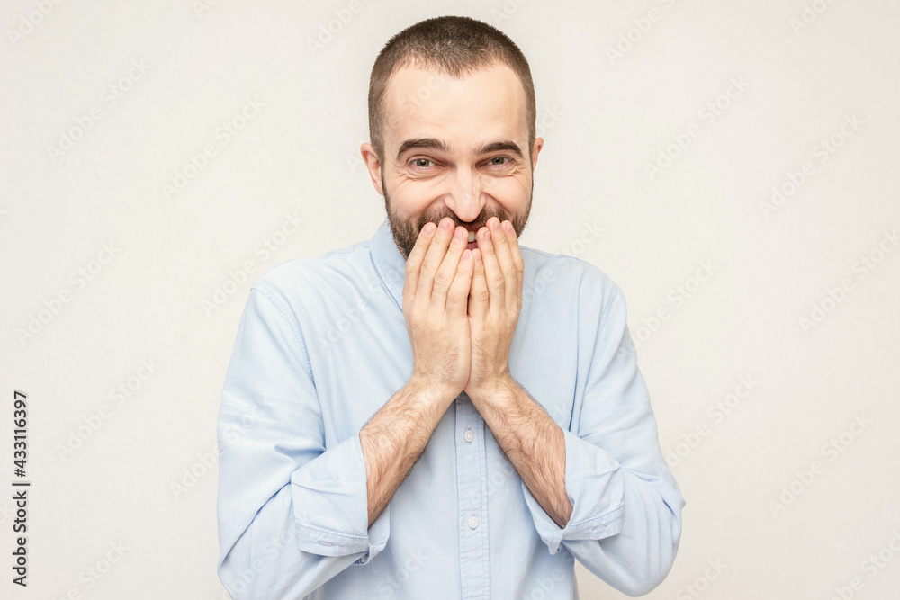 Giggling bearded man covers his mouth from, people's positive emotions ...