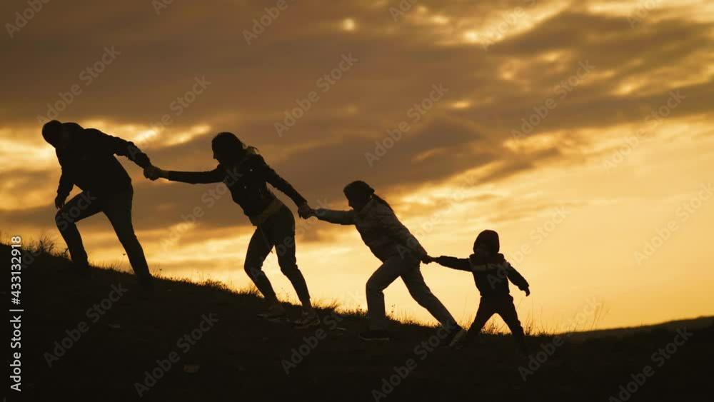 Giving a helping hand. Silhouette of family helping each other on top ...