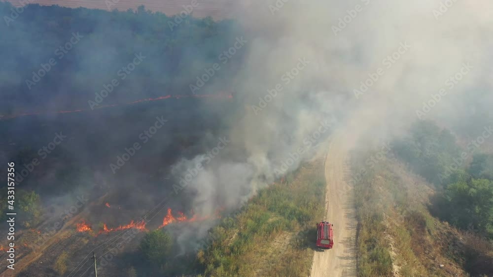 fire trucks drive through clouds of forest fire smoke. dangerous work ...