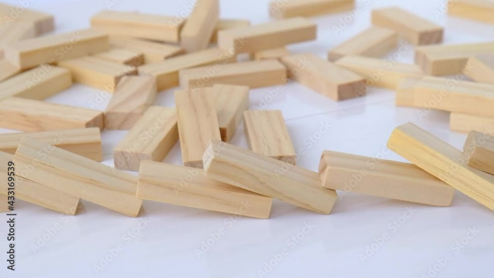 Vidéo Stock Domino effect, row of wooden domino falling down on white ...