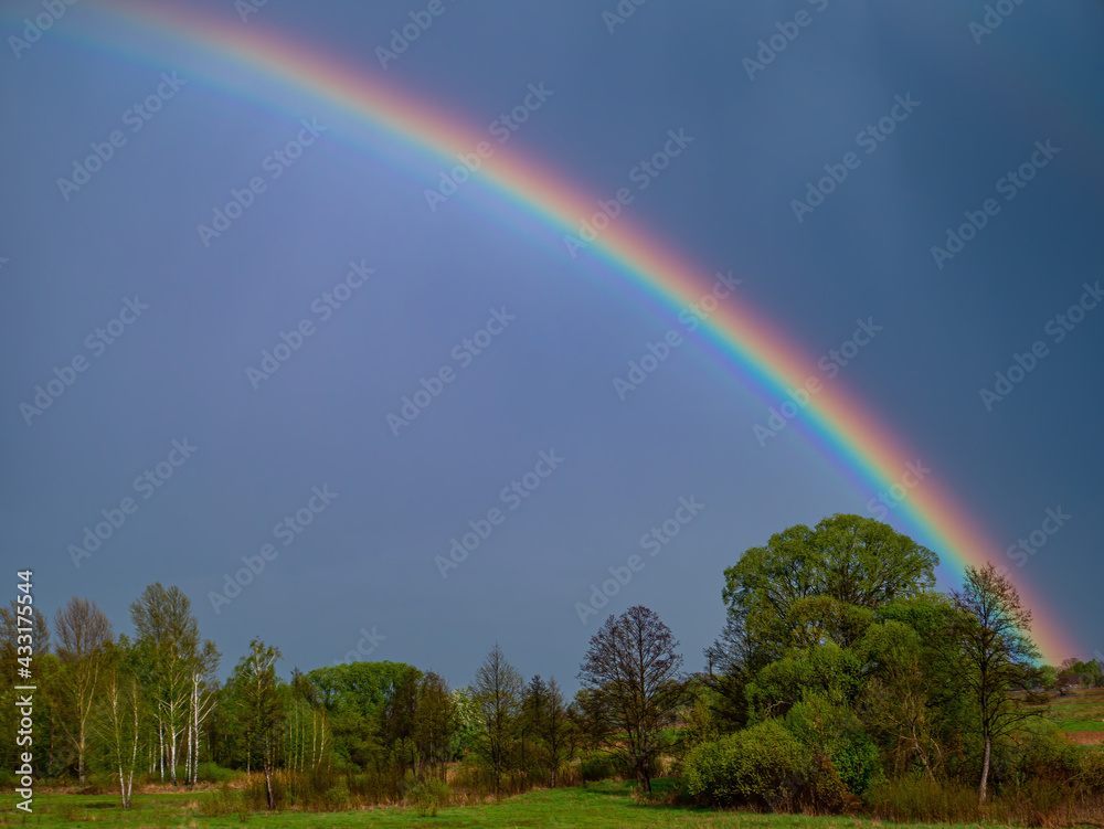 Rainbow with rain clouds in the sky. Colored rainbow. Color spectrum ...