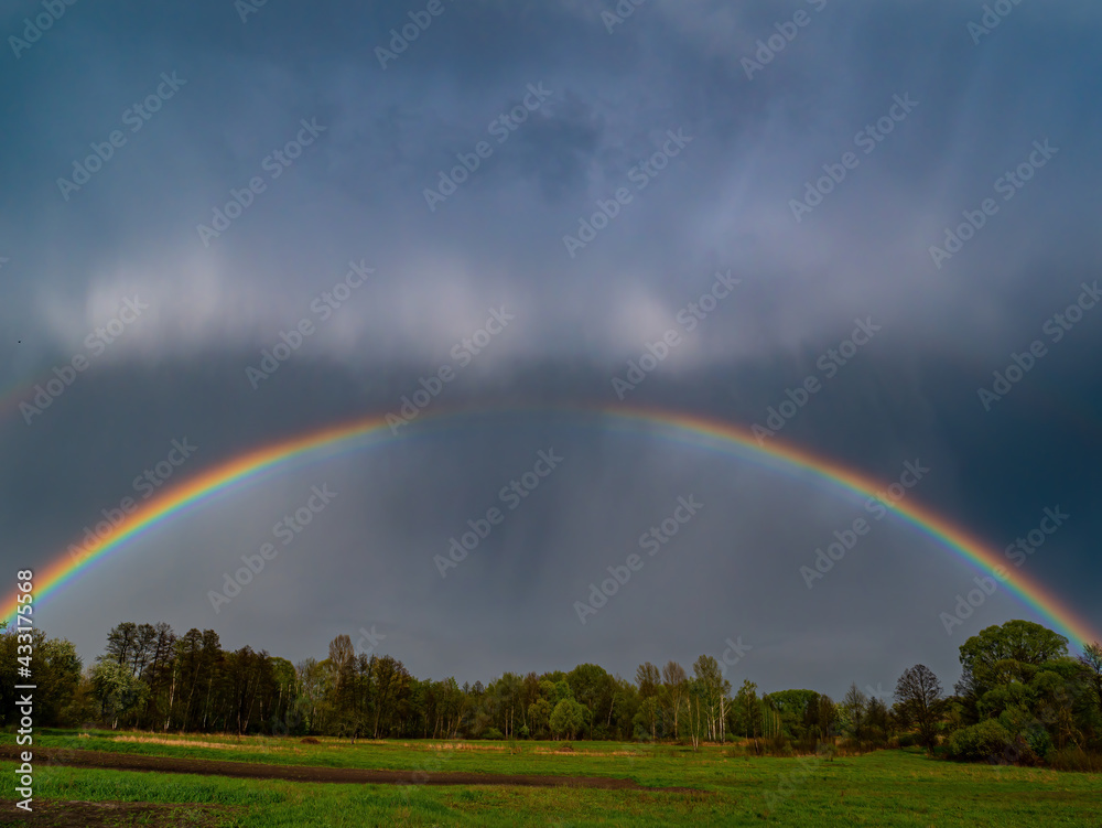 Rainbow with rain clouds in the sky. Colored rainbow. Color spectrum ...