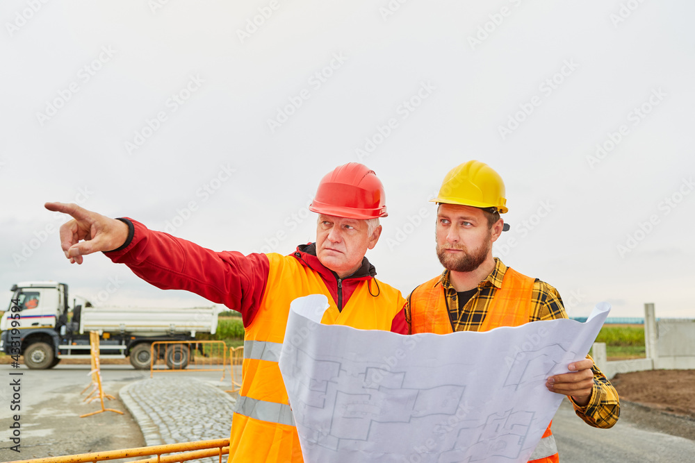 Construction manager and foreman with construction plan on the ...