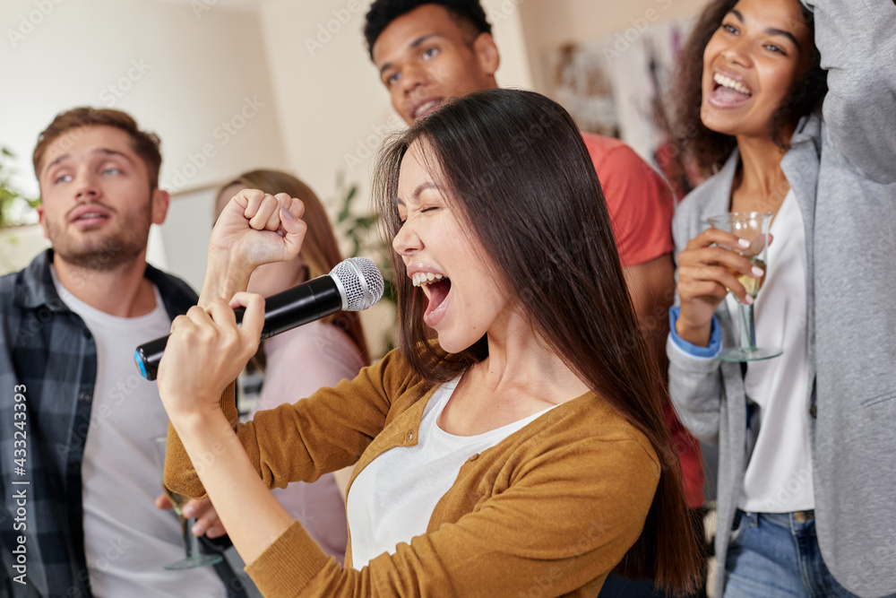 Foto de Perform like a superstar. Pretty young asian girl holding ...