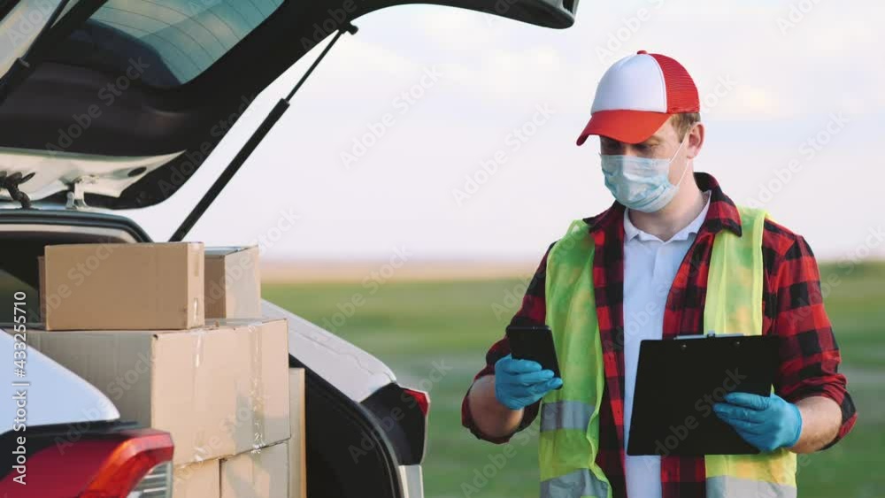 Young delivery man checking list. Delivery man in cap and documentation ...