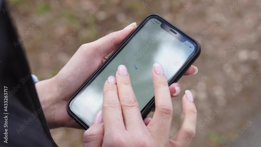 Tourist looks maps mobile phone. Use your fingers zoom out location ...