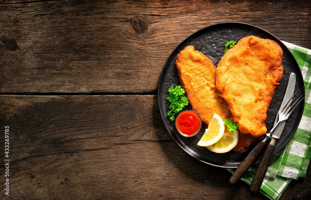 Homemade breaded wiener schnitzel served with parsley and lemon slices Stock Photo | Adobe Stock
