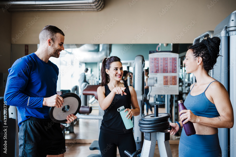 Male and female athlete friends talking while standing in gym Stock ...