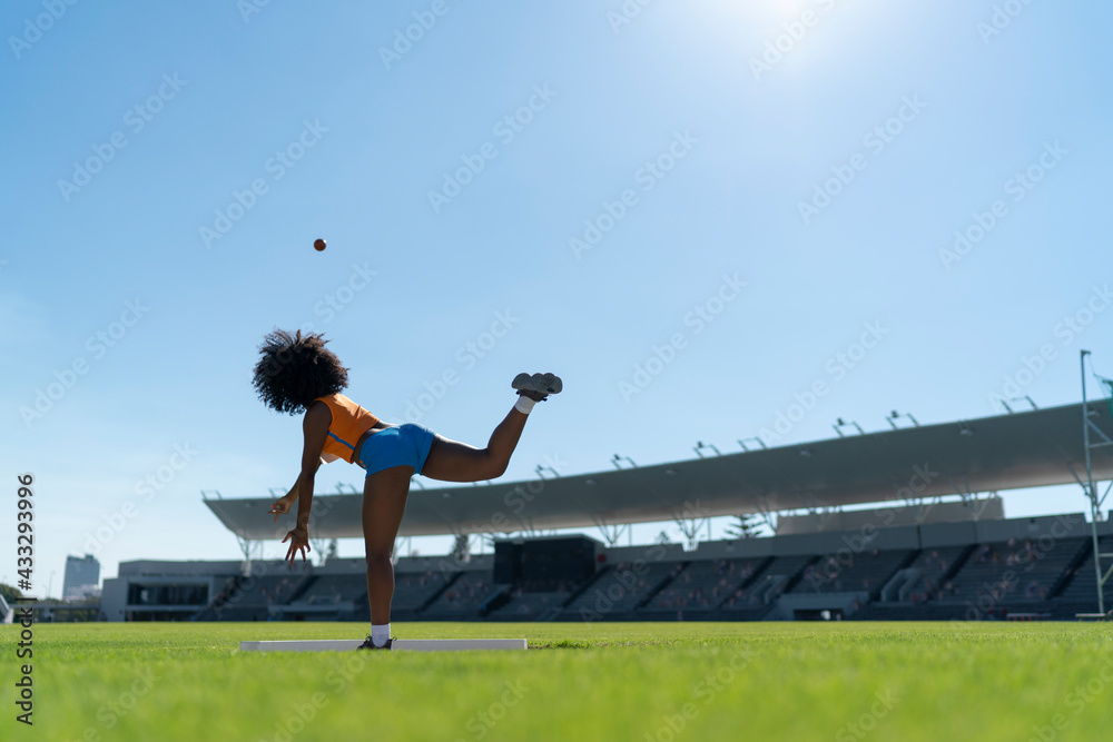 Foto de Female track and field athlete throwing shot put in sunny ...
