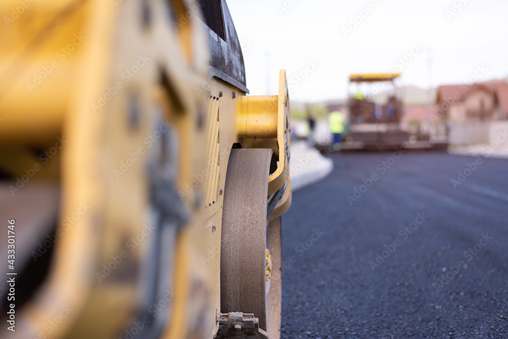 Modern heavy asphalt roller that stack and press hot asphalt. Yellow ...