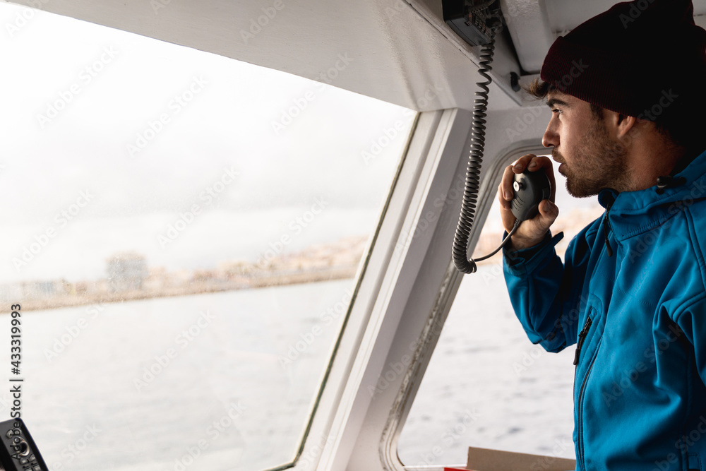Young skipper man sailing a boat working during summer vacation - Focus ...