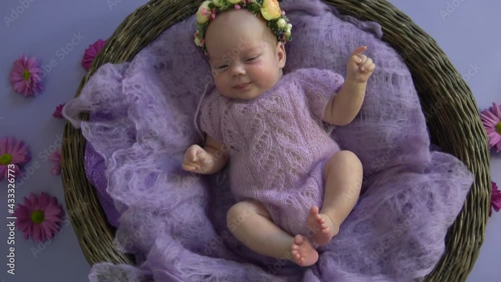 newborn girl in purple on a purple background in the colors of the ...