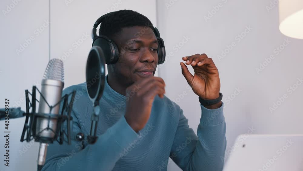 Man wearing headphones taking an online class using a laptop and ...