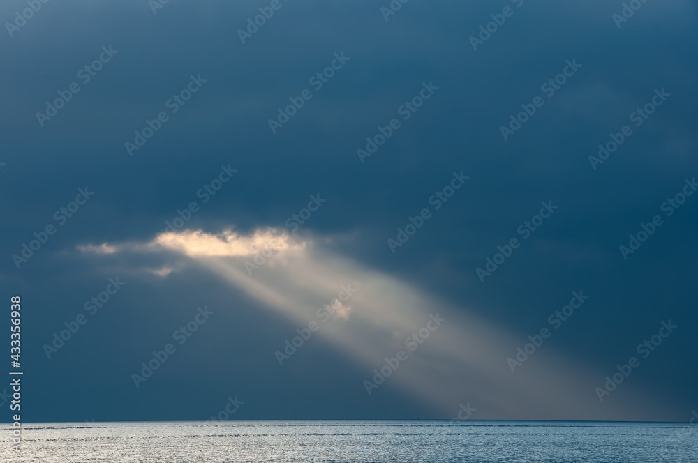 Gorgeous sunbeam coming out from behind the dark clouds illuminating ...